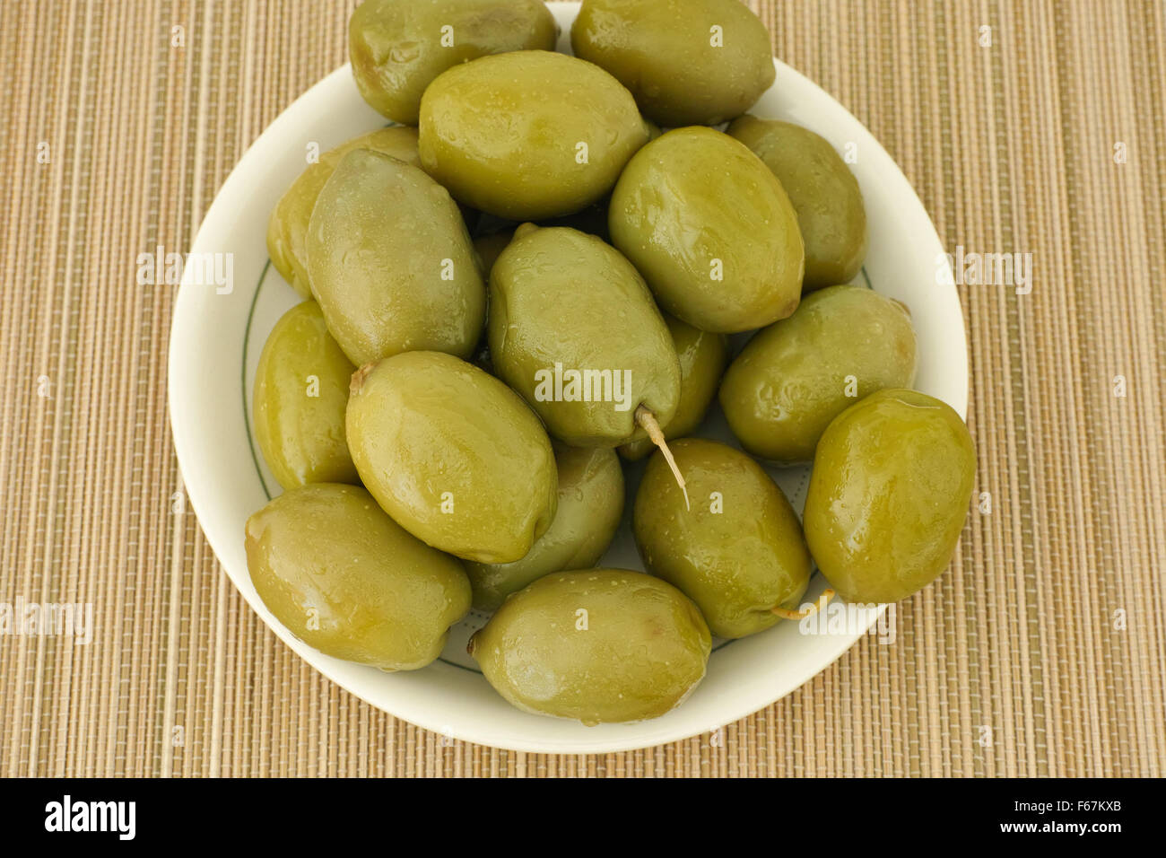 Pile of green olives in a small plate Stock Photo - Alamy