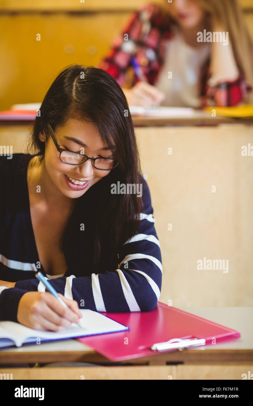 Smiling student writing on notebook Stock Photo - Alamy