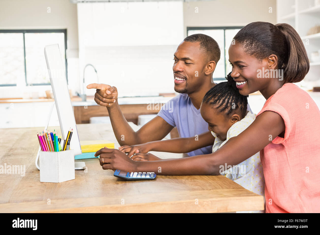 Smiling casual family on a computer Stock Photo - Alamy