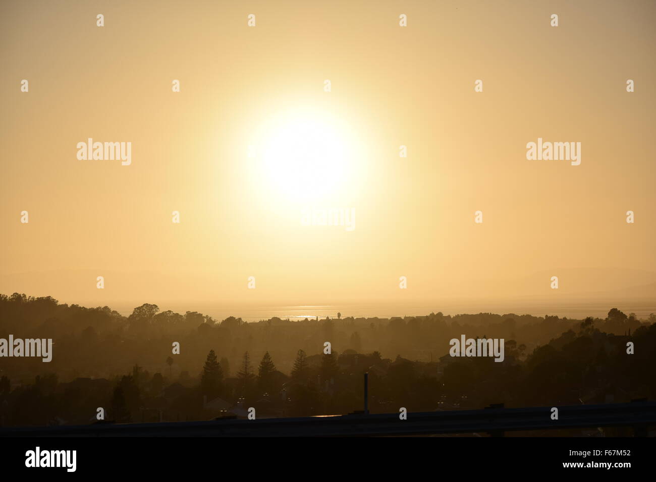 Sun Setting over the land and ocean, filling the sky with golden light ...