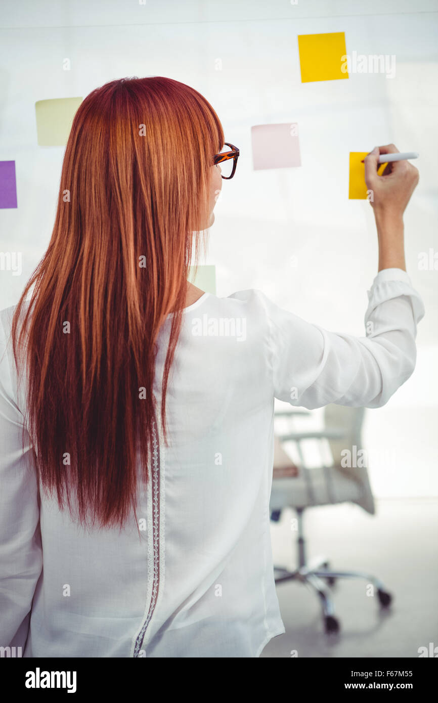 Attractive hipster woman writing on sticky notes Stock Photo - Alamy