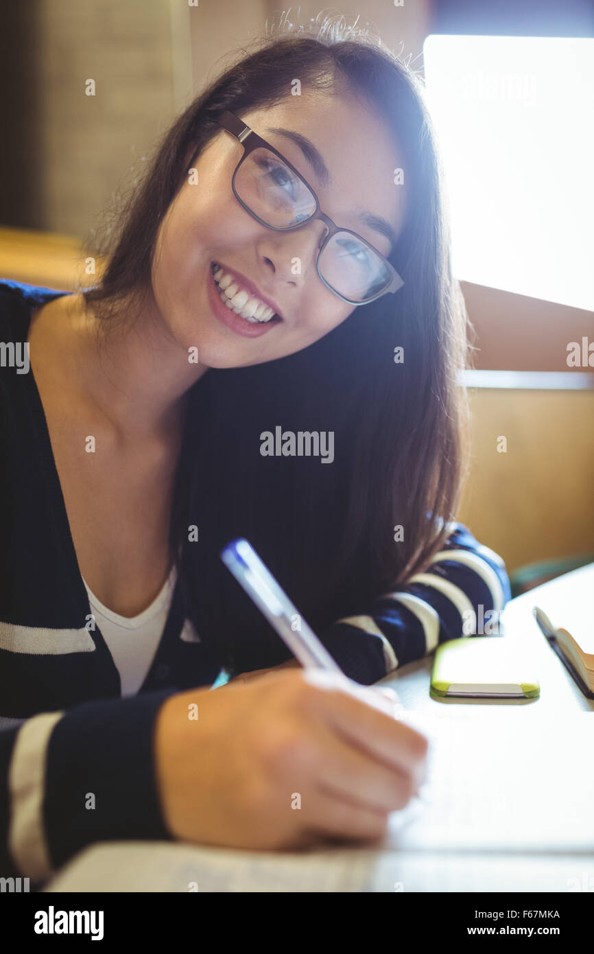 Smiling student writing on notebook Stock Photo - Alamy