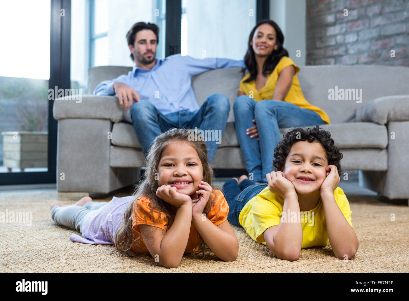 Children laying on the carpet in living room Stock Photo - Alamy