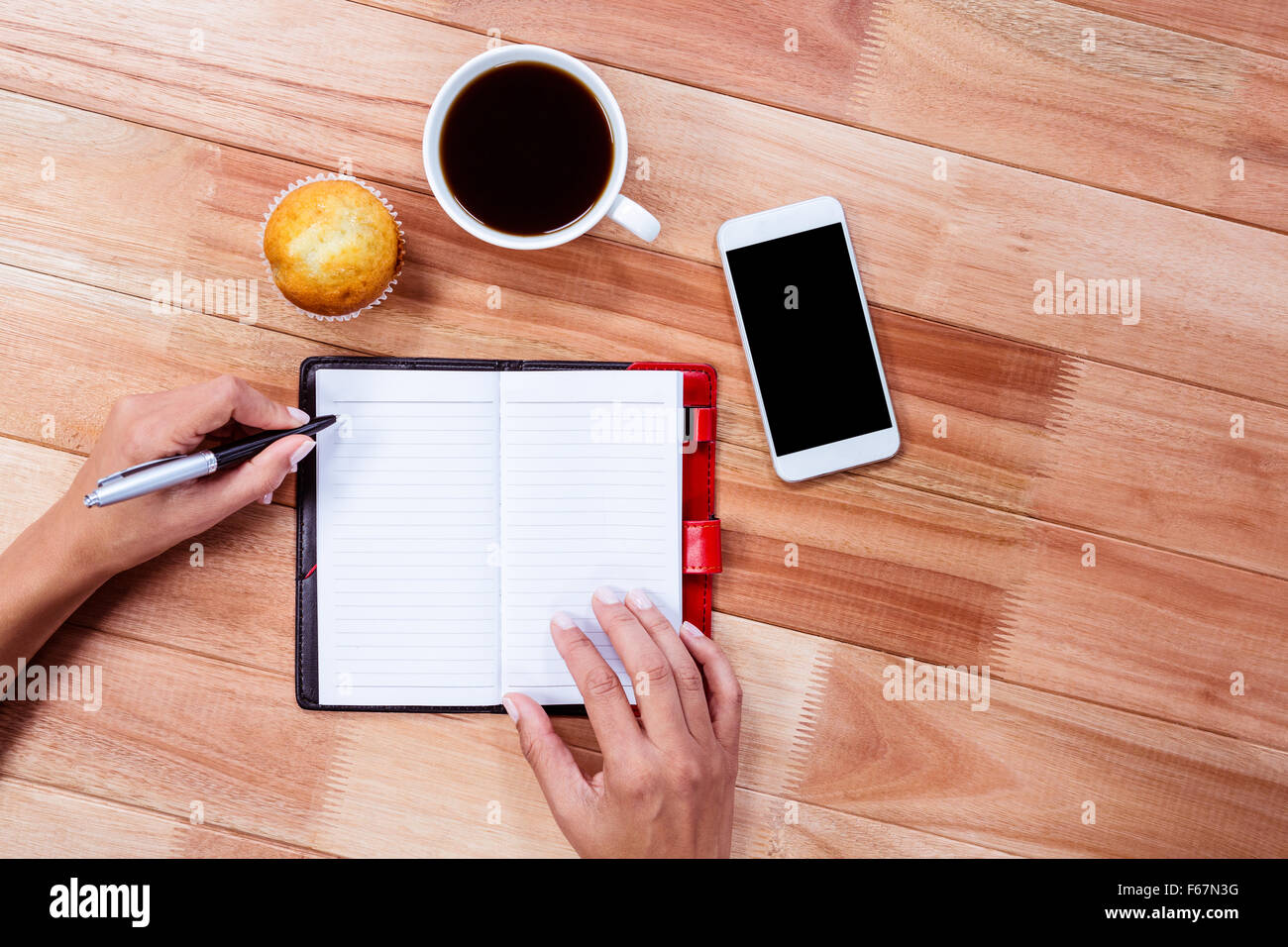 Overhead of feminine hands writing on agenda Stock Photo - Alamy