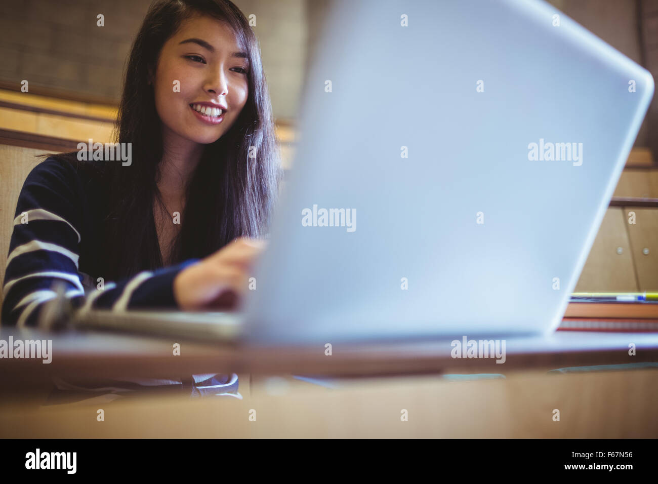 Happy student in lecture hall using laptop Stock Photo - Alamy
