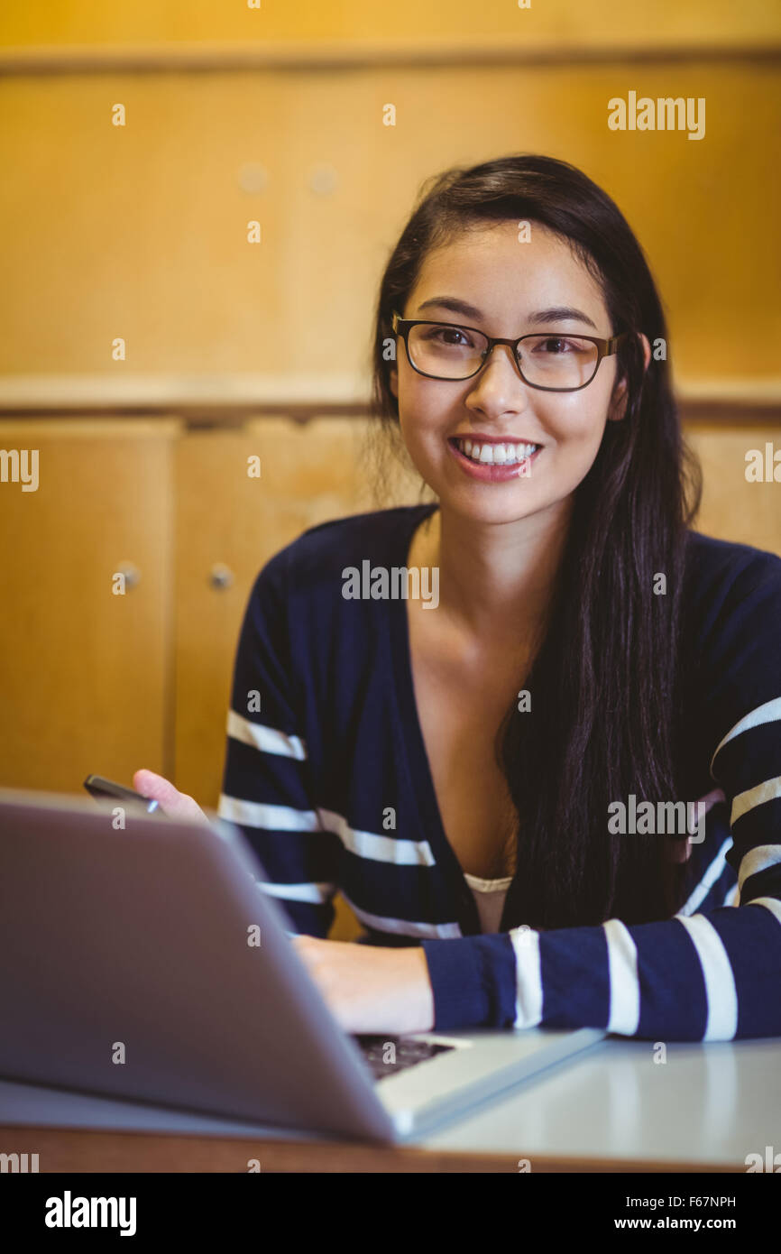 Smiling student using laptop during class Stock Photo - Alamy
