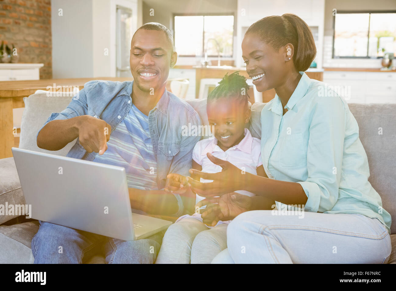 Happy family using laptop on the couch Stock Photo - Alamy