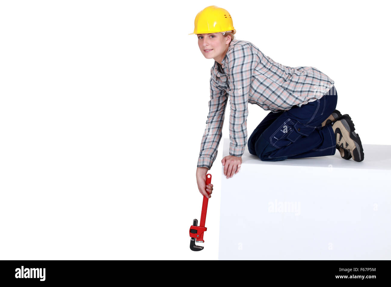 Woman reaching down with a wrench Stock Photo - Alamy