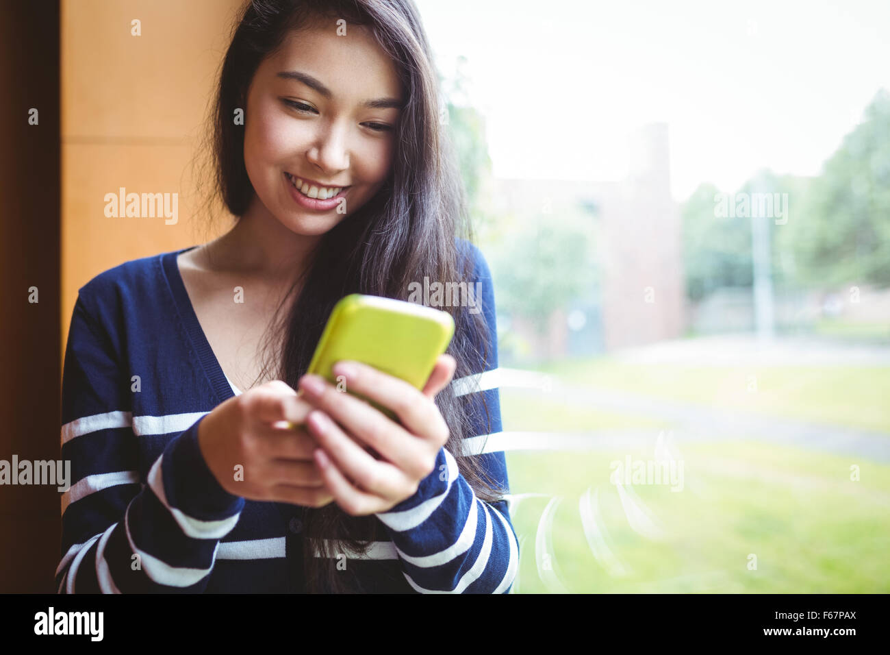 Smiling student using smartphone Stock Photo - Alamy