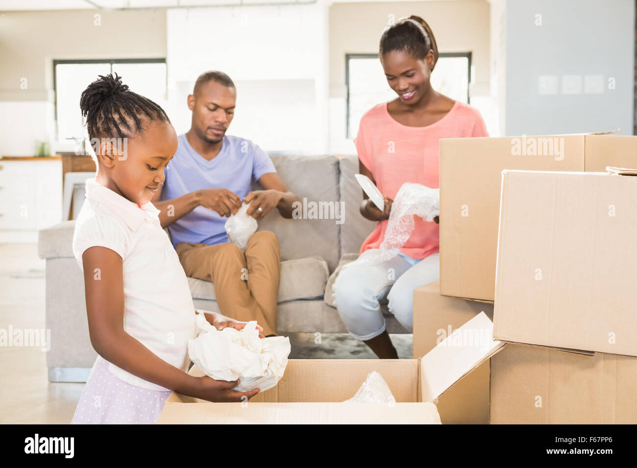 Family unwrapping things in new home Stock Photo - Alamy