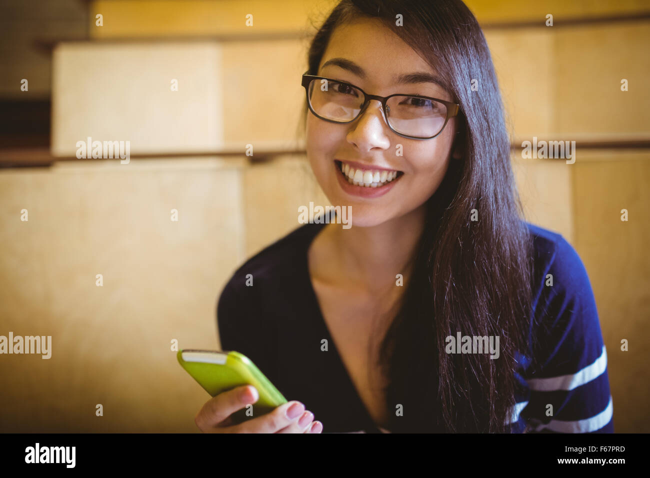 Smiling student texting in lecture hall Stock Photo - Alamy
