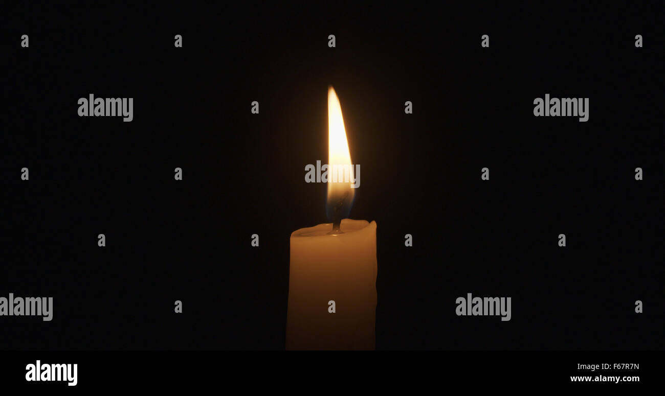 single thin candle with fire on dark Stock Photo - Alamy