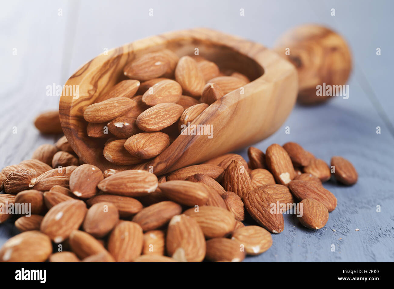 roasted almonds on blue wooden table with scoop Stock Photo - Alamy