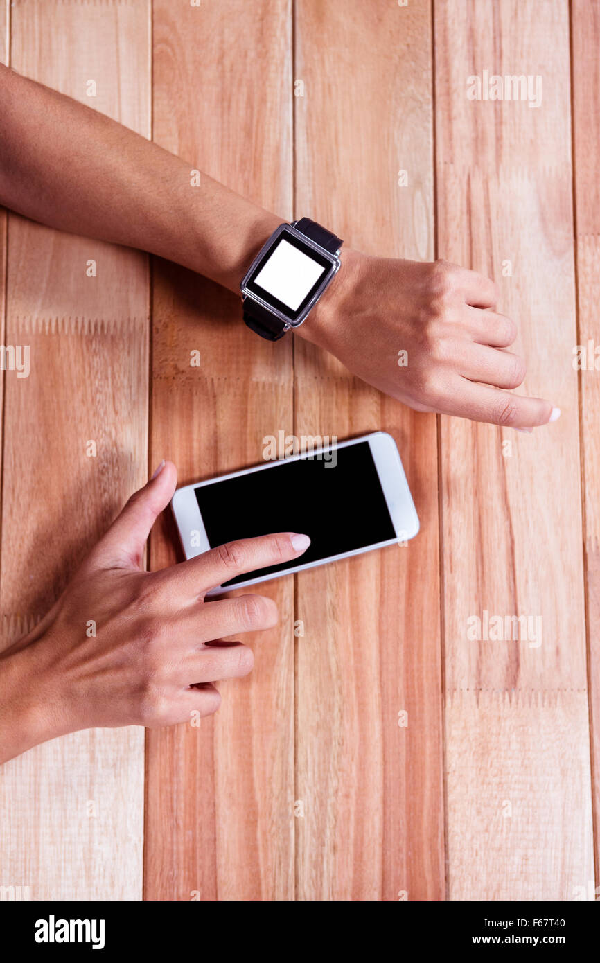 Woman with smartwatch using smartphone Stock Photo - Alamy
