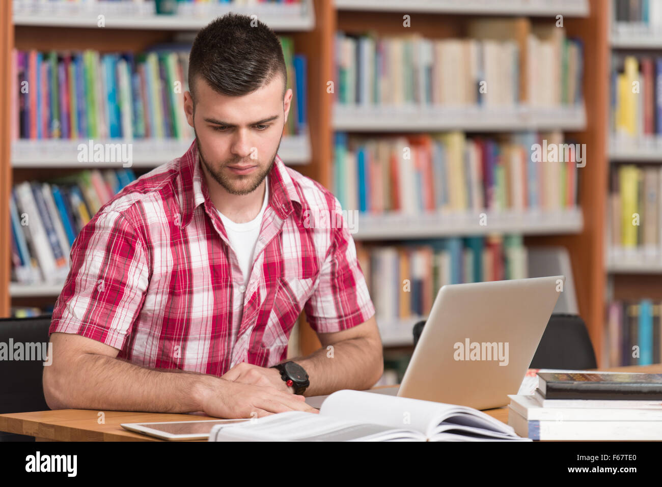In The Library - Handsome Male Student With Laptop And Books Working In ...