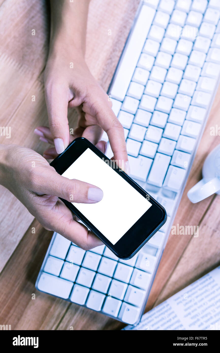 Businesswoman using her smartphone on desk Stock Photo - Alamy