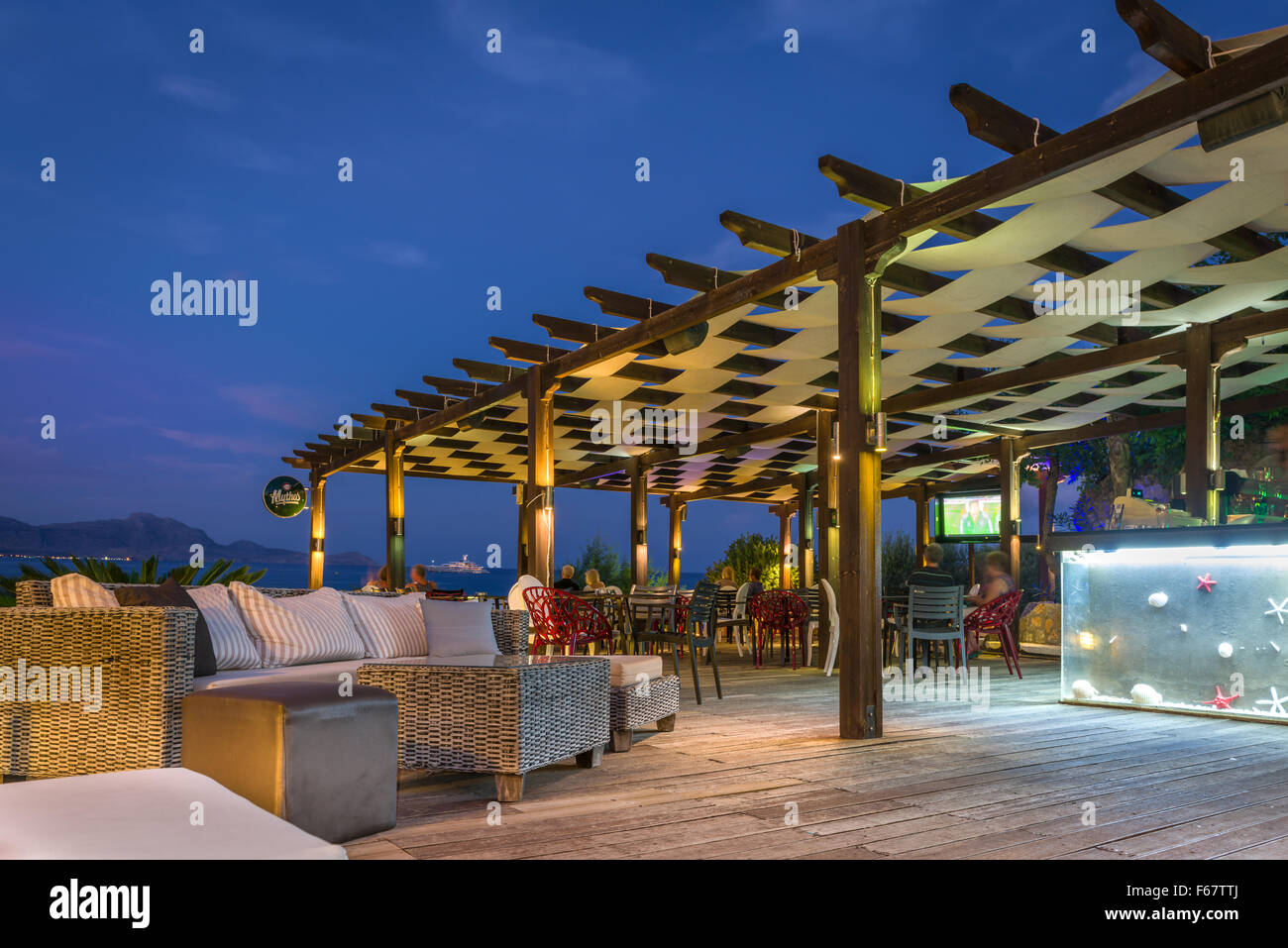 People enjoy the view from one of the beach bars along the coast from ...