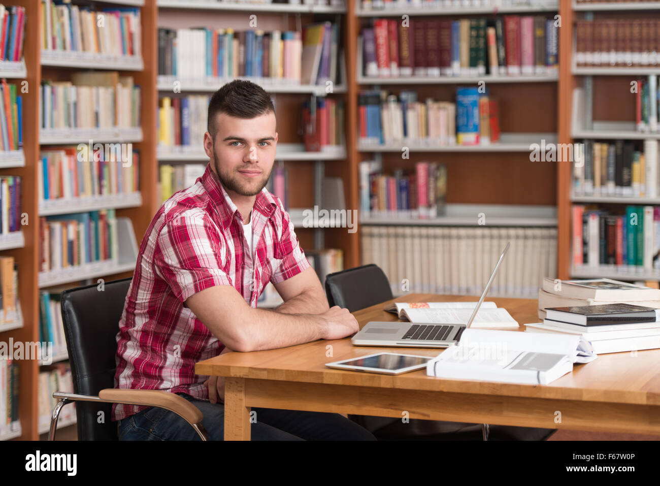 In The Library - Handsome Male Student With Laptop And Books Working In ...