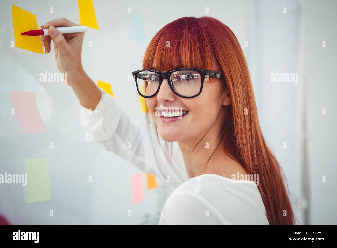 Attractive hipster woman writing on sticky notes Stock Photo - Alamy