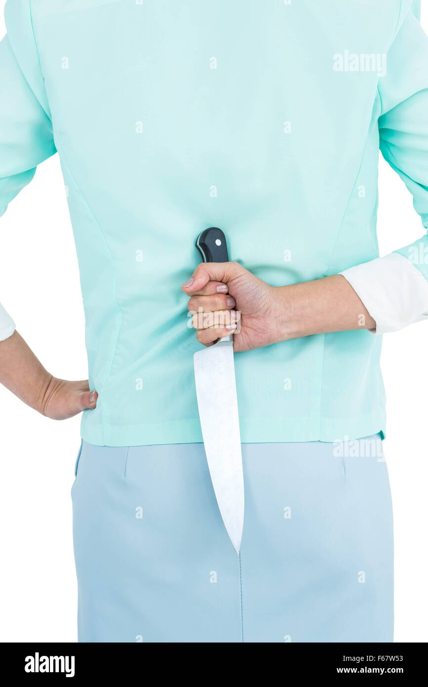 Rear view of businesswoman hiding knife in her back Stock Photo - Alamy