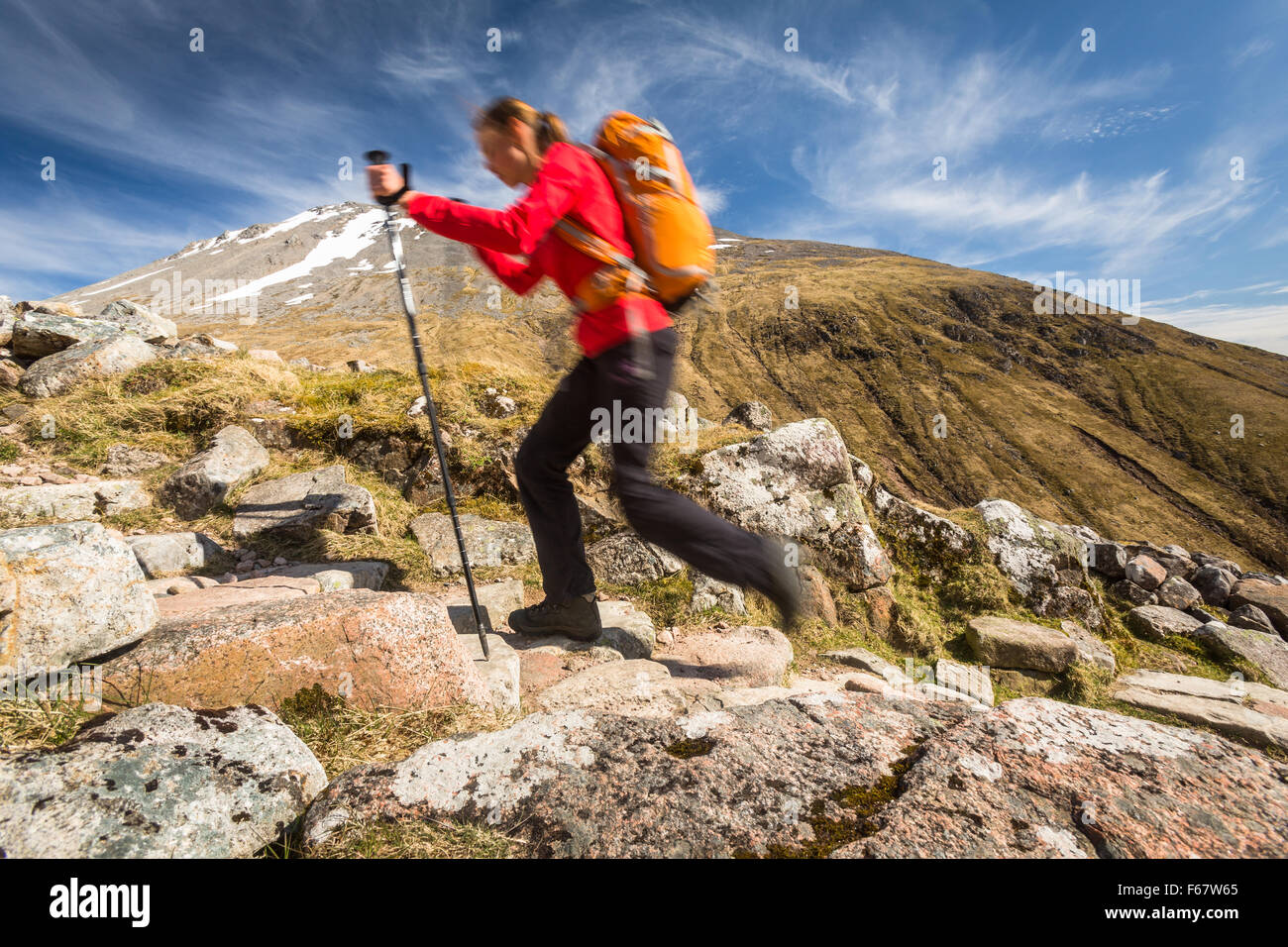 Pretty, young female hiker going uphill Stock Photo - Alamy