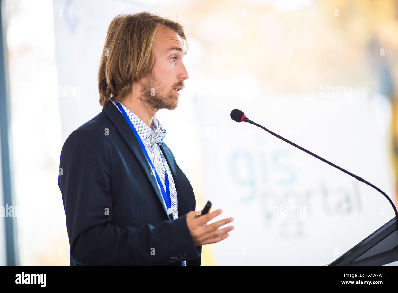 Handsome young man giving a speech at a conference Stock Photo - Alamy