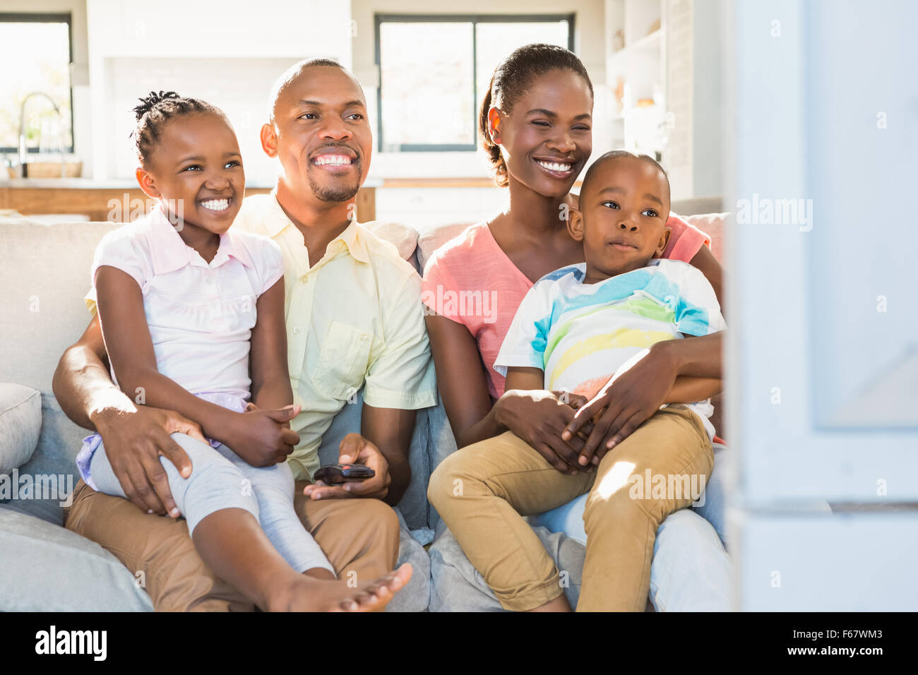 Portrait of a family of four watching tv Stock Photo - Alamy