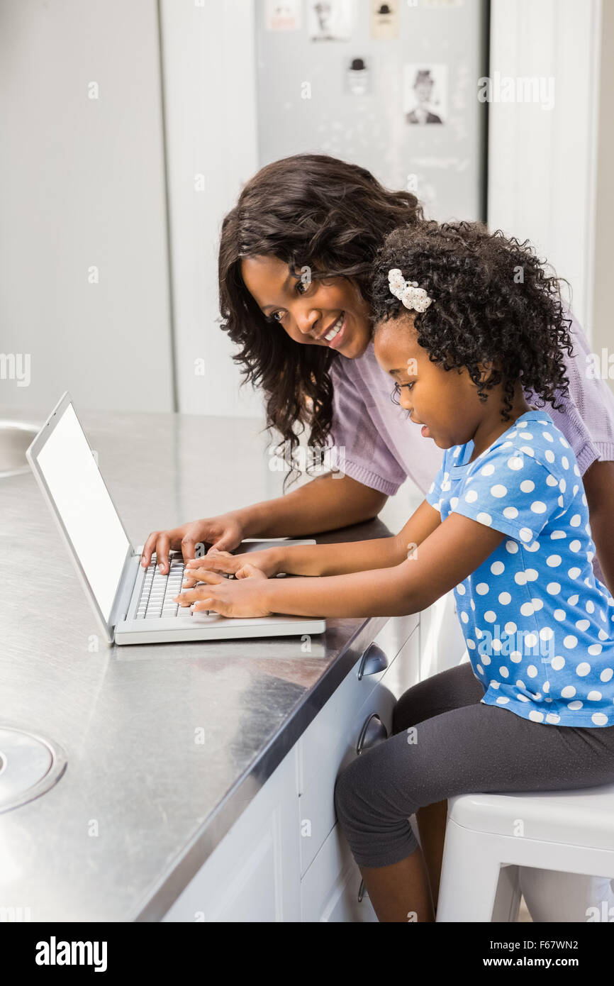 Daughter using laptop with mother Stock Photo - Alamy