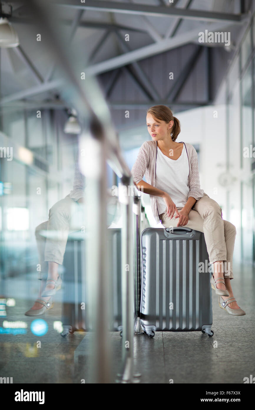 Young female passenger at the airport, about to check-in Stock Photo ...