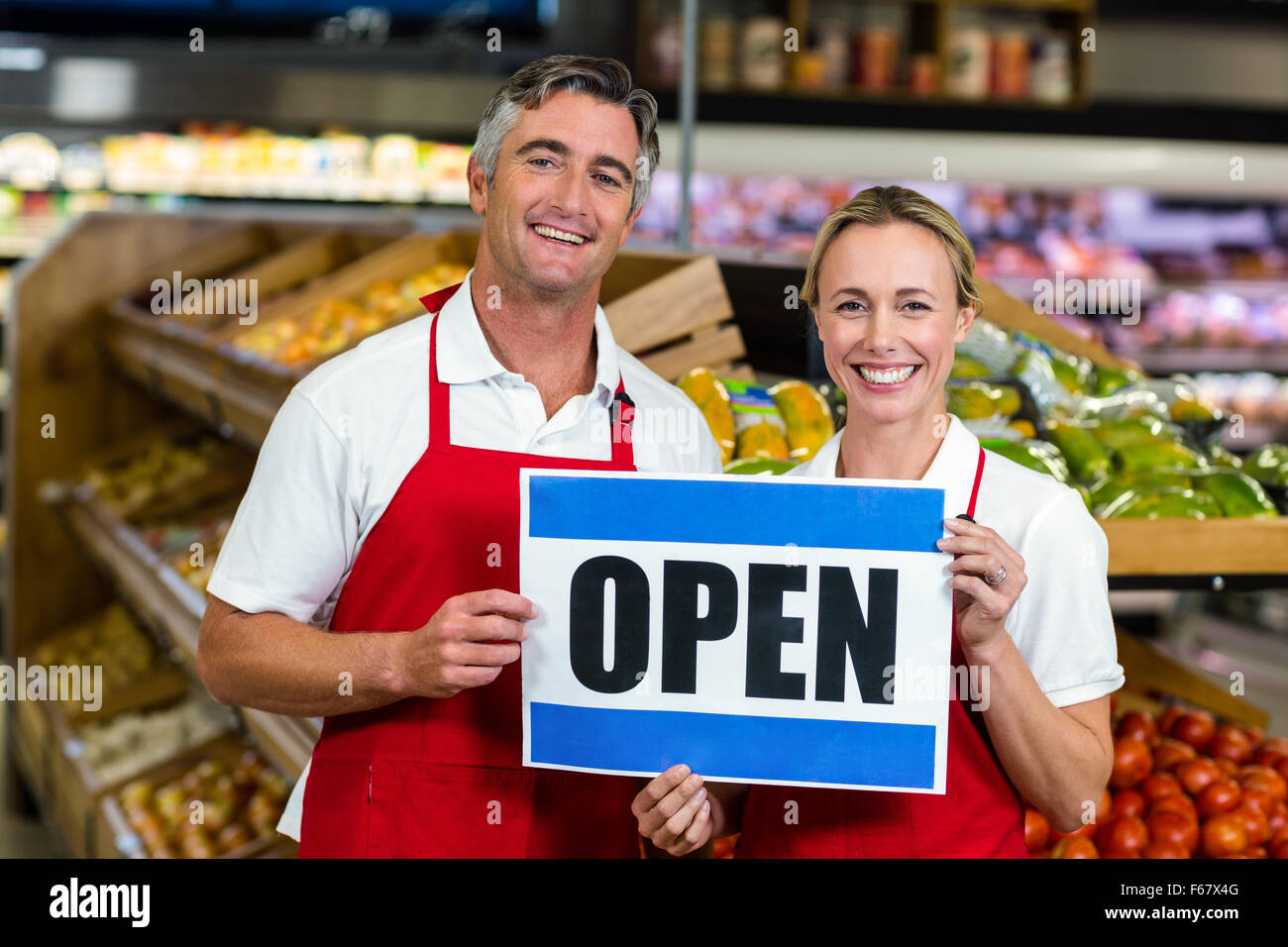Smiling colleagues holding sign together Stock Photo - Alamy