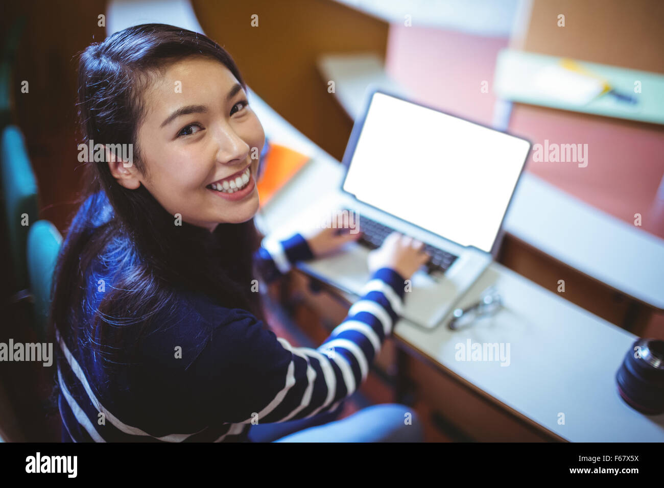 Happy student in lecture hall using laptop Stock Photo - Alamy