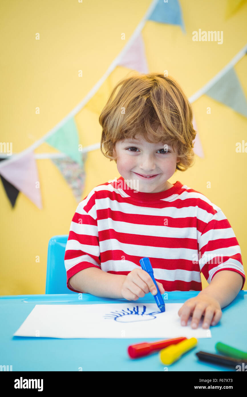 Smiling boy colouring some paper Stock Photo - Alamy