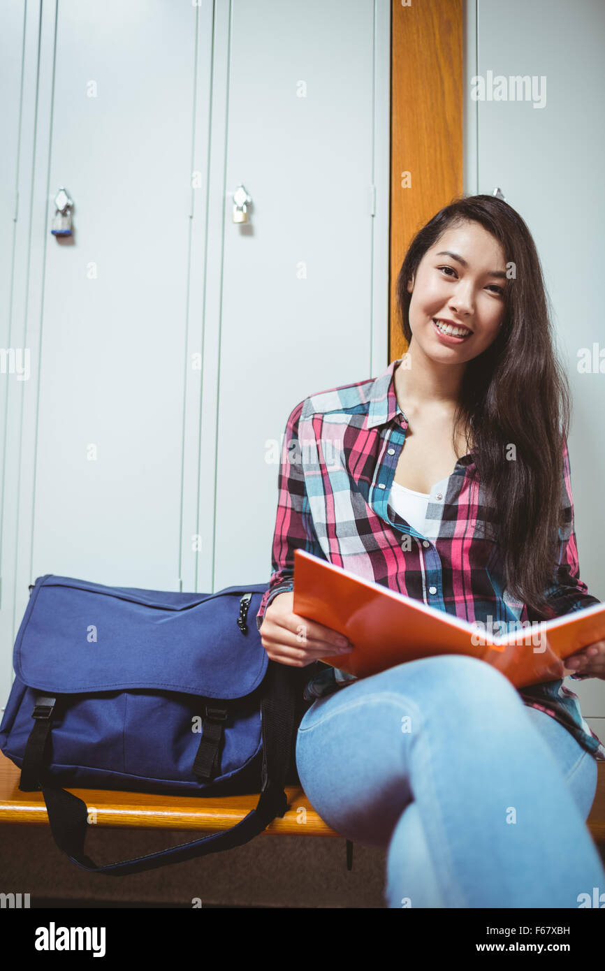 Smiling student sitting and reading a notebook Stock Photo - Alamy