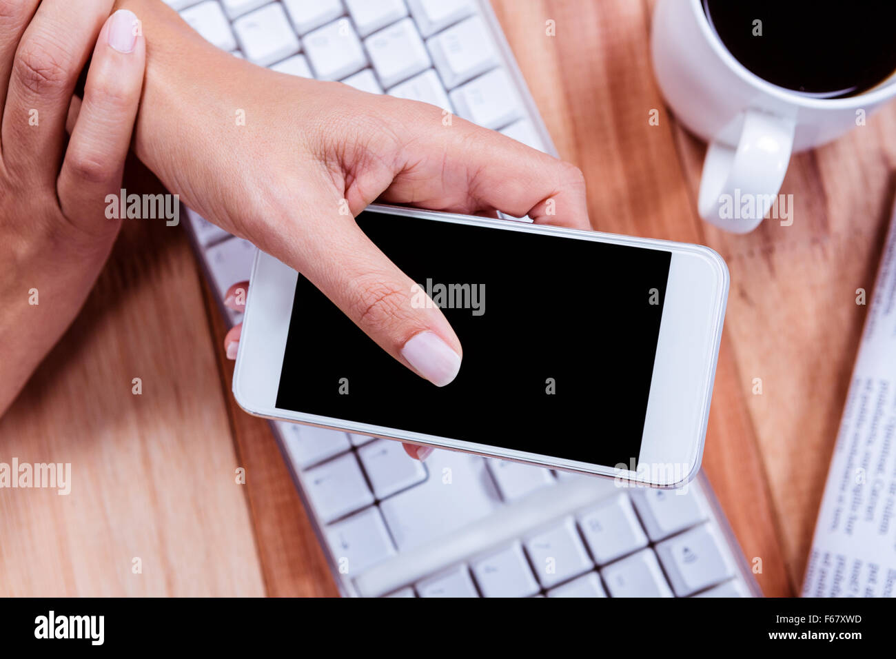 Businesswoman using her smartphone on desk Stock Photo - Alamy