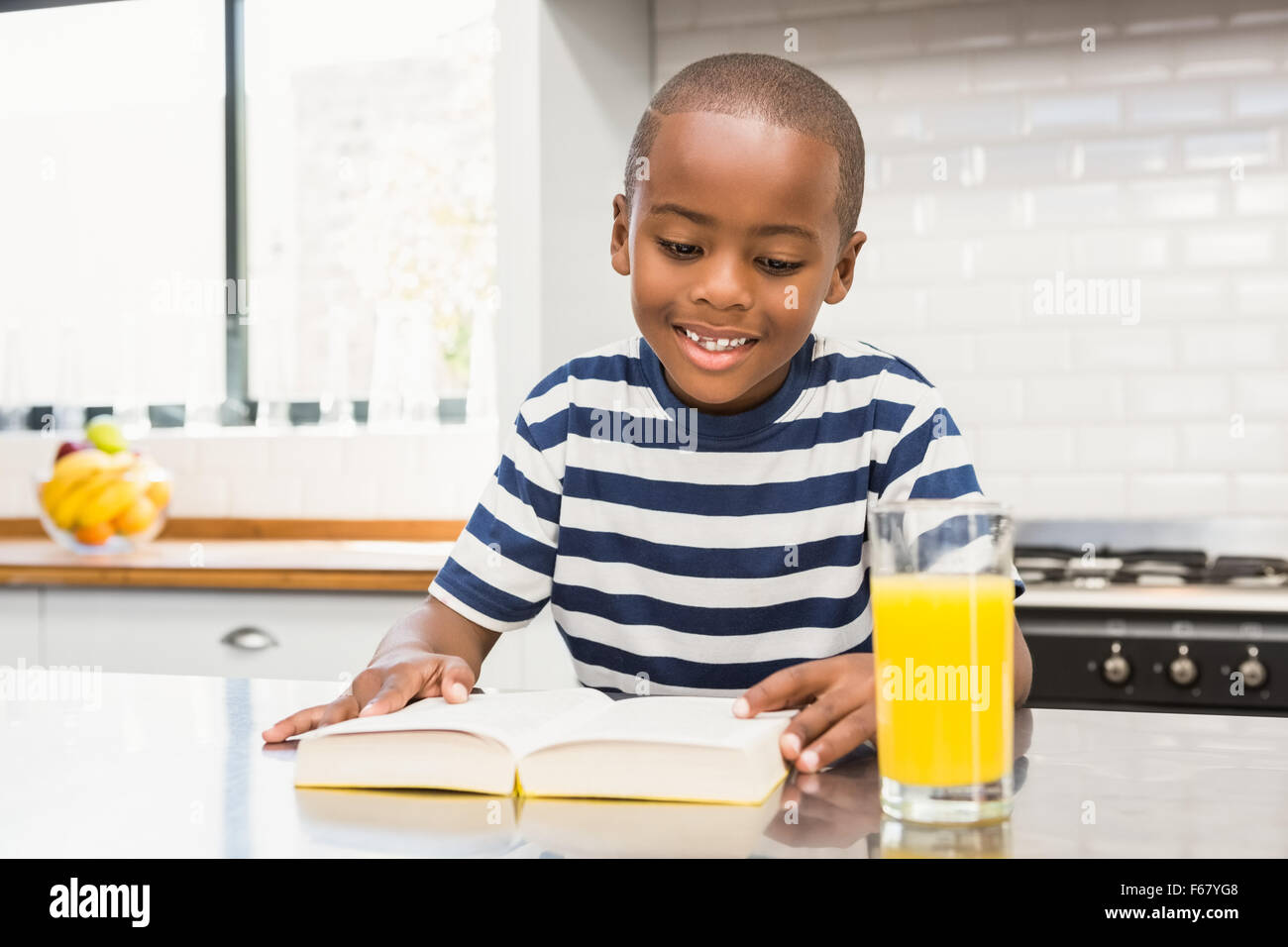 Smiling boy reading a book Stock Photo - Alamy