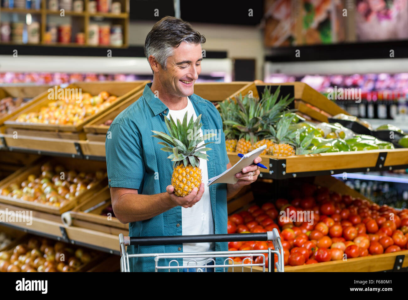 Smiling man looking at his list Stock Photo - Alamy