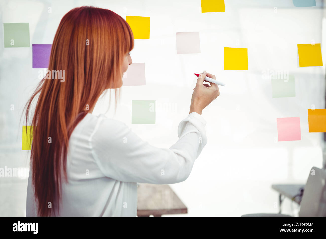 Attractive hipster woman writing on sticky notes Stock Photo - Alamy