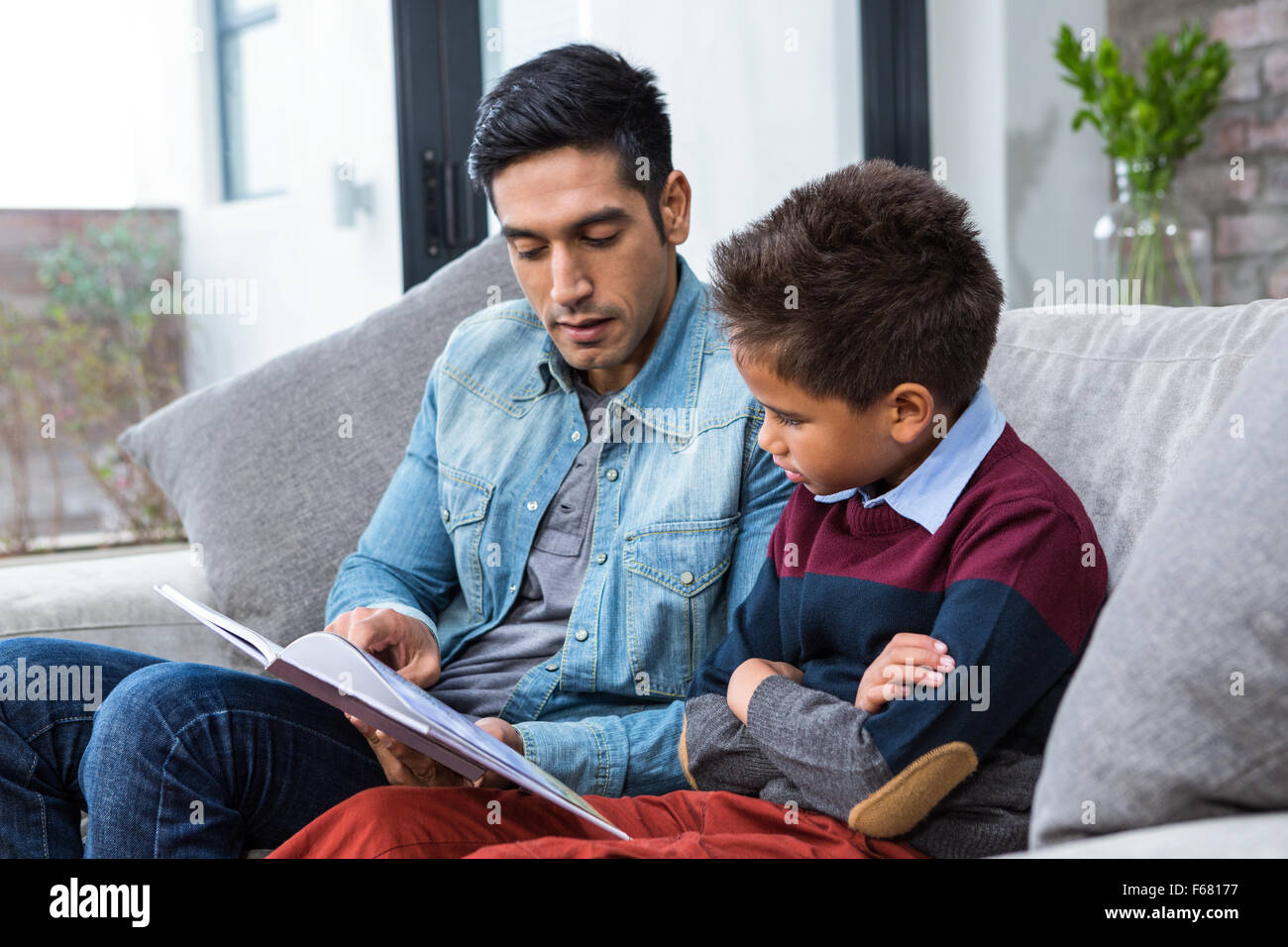 Happy father reading book with his son Stock Photo - Alamy