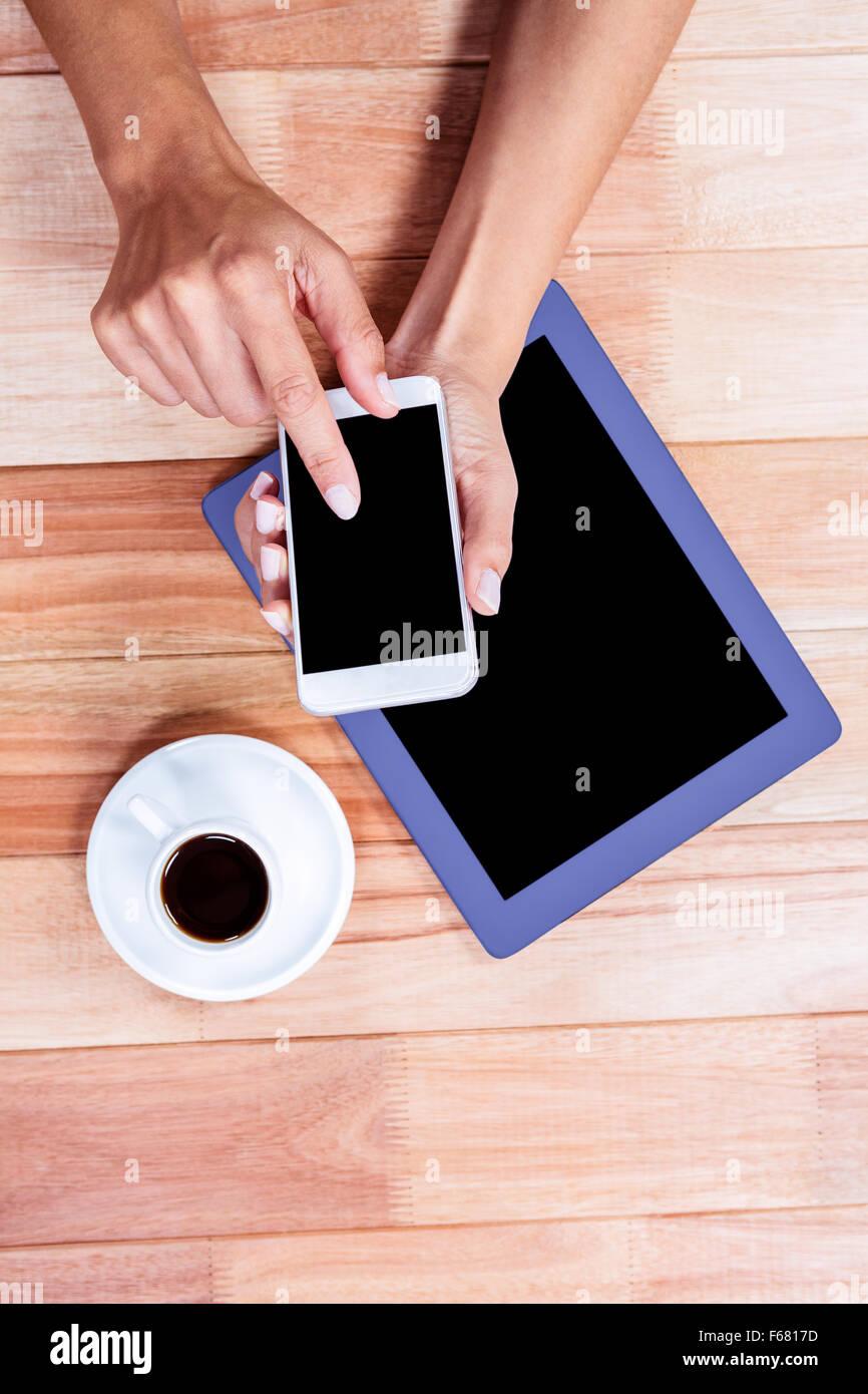 Businesswoman using her smartphone on desk Stock Photo - Alamy
