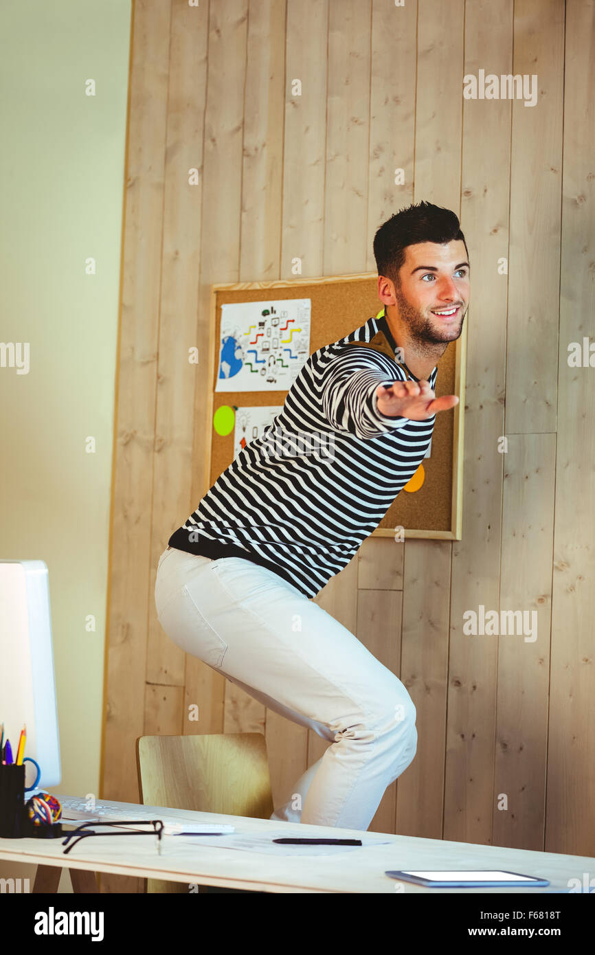 Man pretending to surf on his chair Stock Photo - Alamy