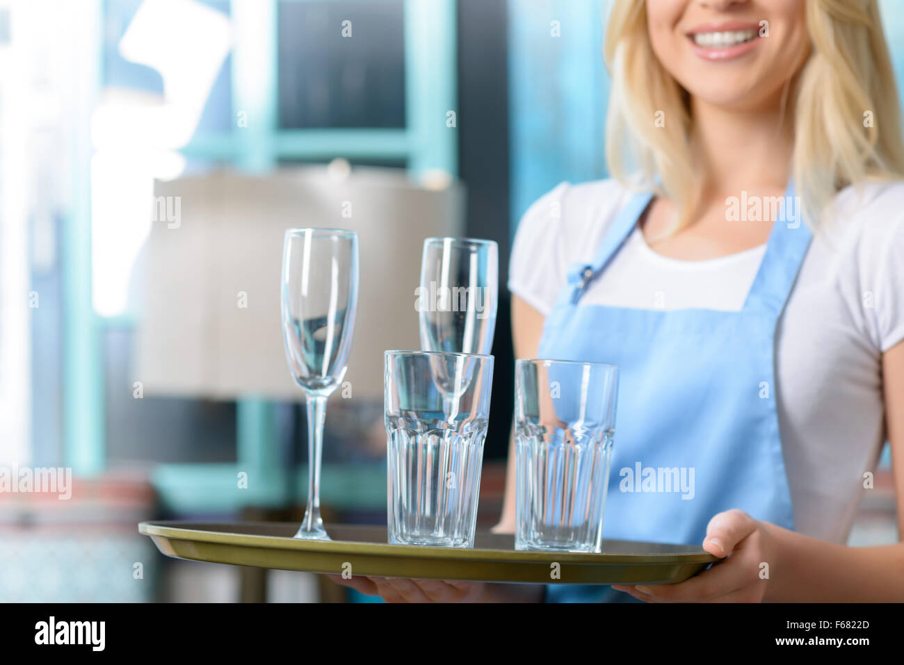 Pleasant waitress holding tray Stock Photo - Alamy