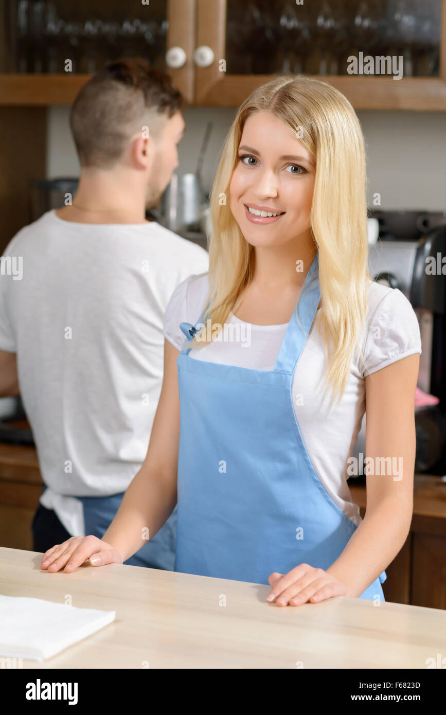 Pleasant waitress standing at a counter Stock Photo - Alamy