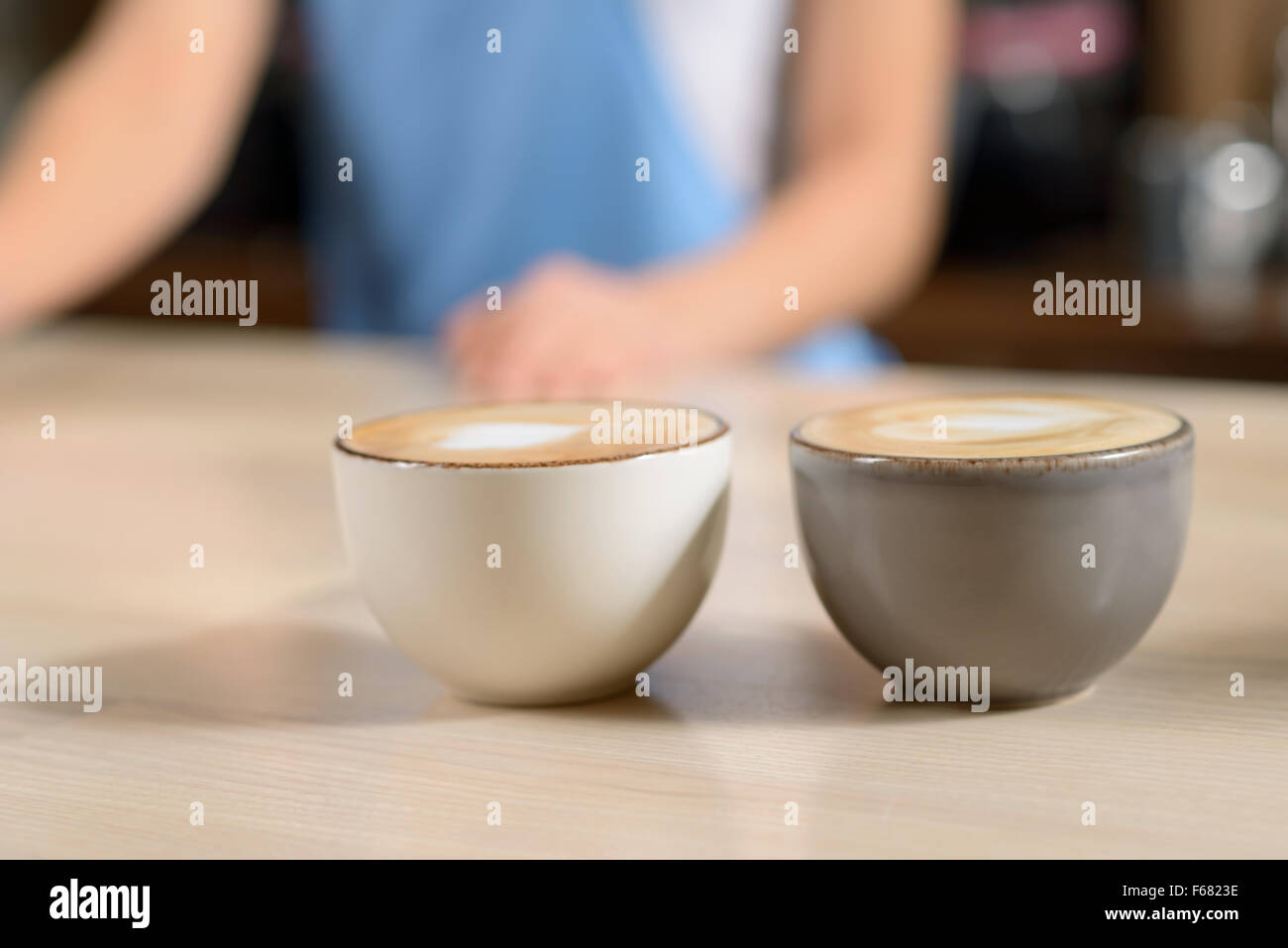 Pleasant waitress standing at a counter Stock Photo - Alamy