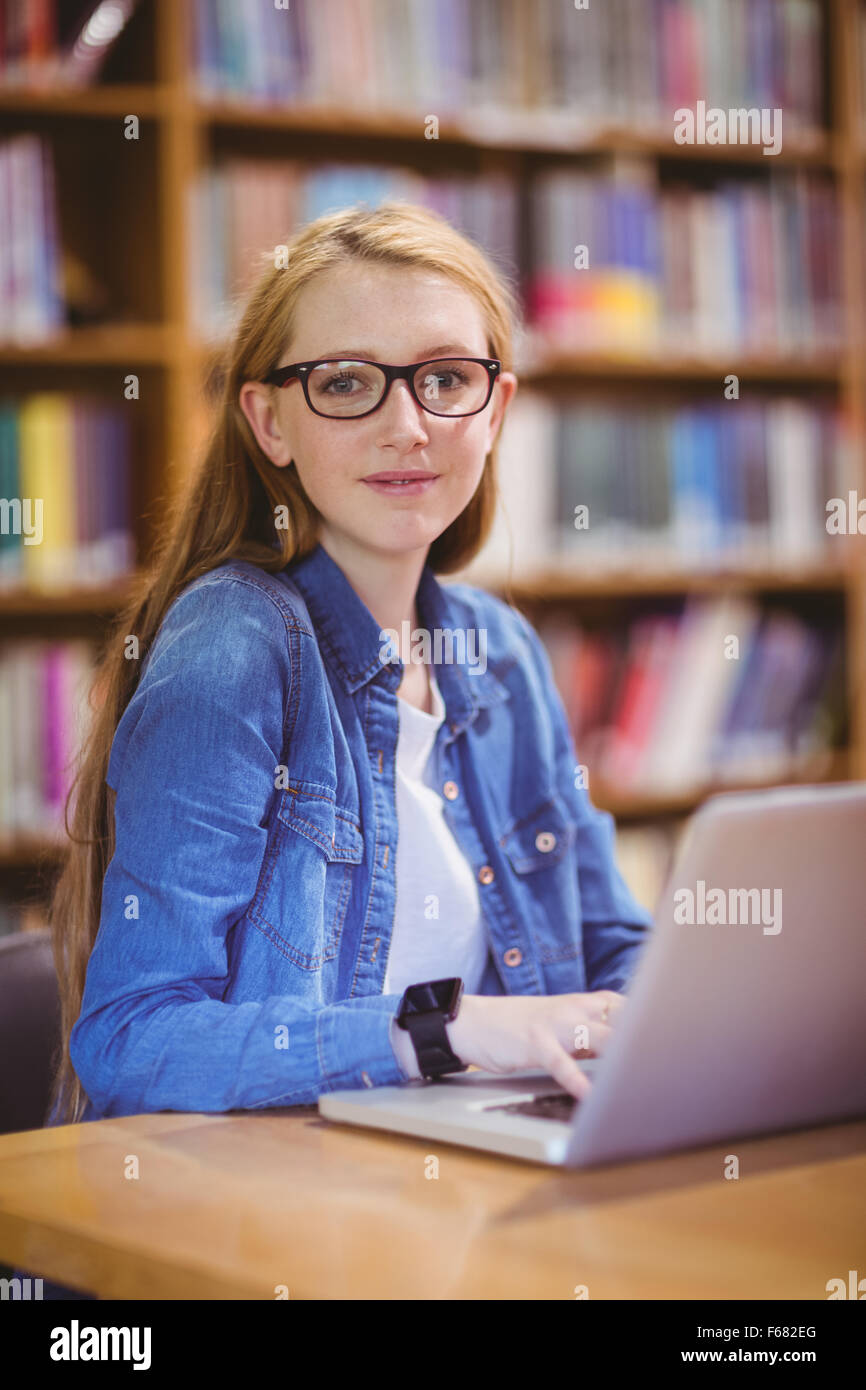 Student with smartwatch using laptop in library Stock Photo - Alamy