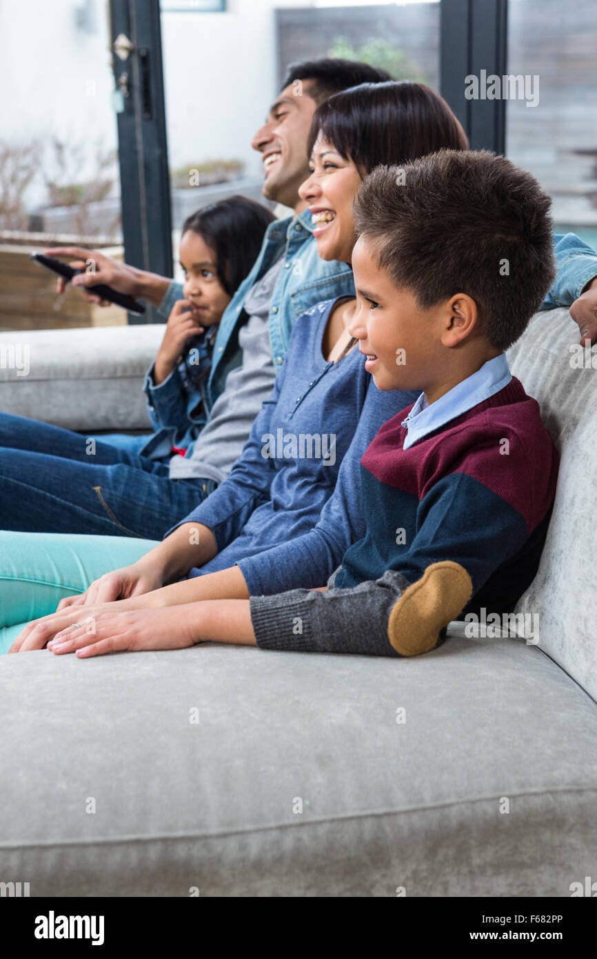 Happy young family watching tv Stock Photo - Alamy