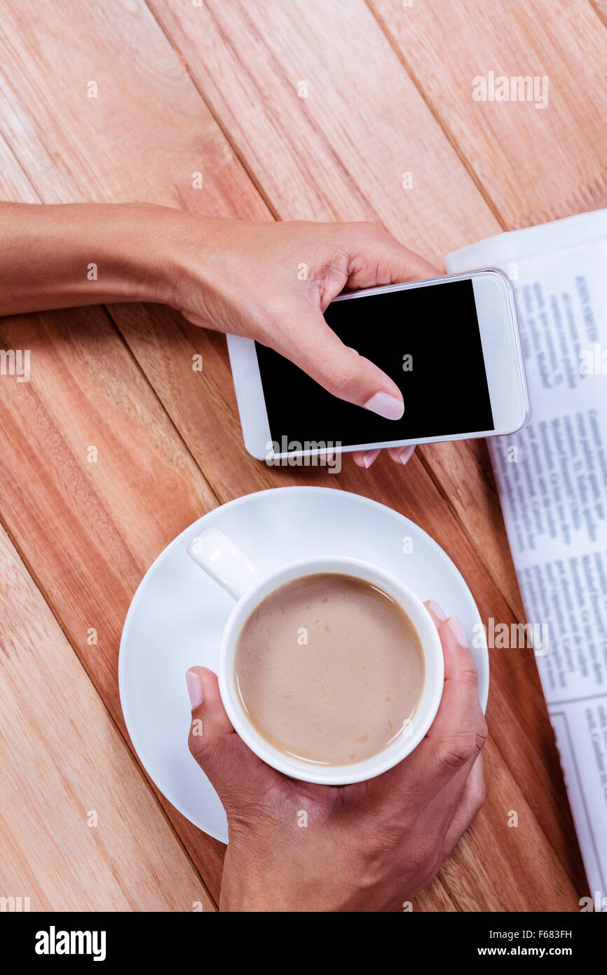 Part of hands holding coffee and smartphone Stock Photo - Alamy
