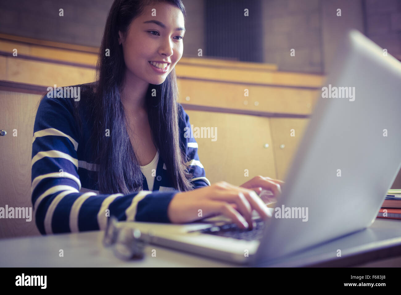 Smiling student using laptop Stock Photo - Alamy