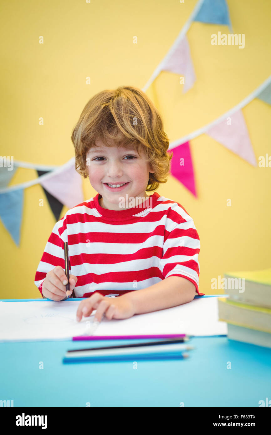 Boy using a pencil to write on paper Stock Photo - Alamy
