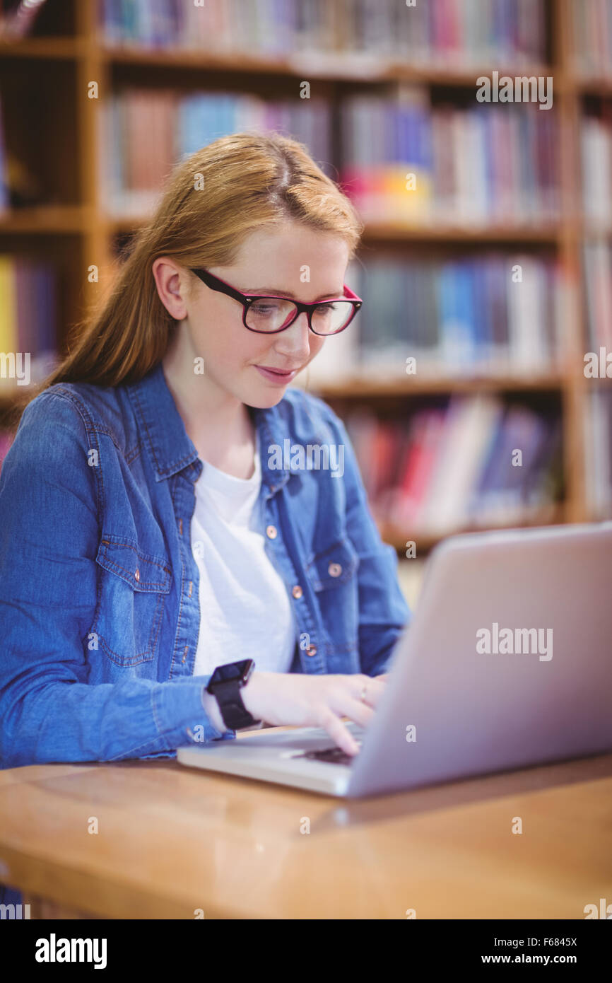 Student with smartwatch using laptop in library Stock Photo - Alamy