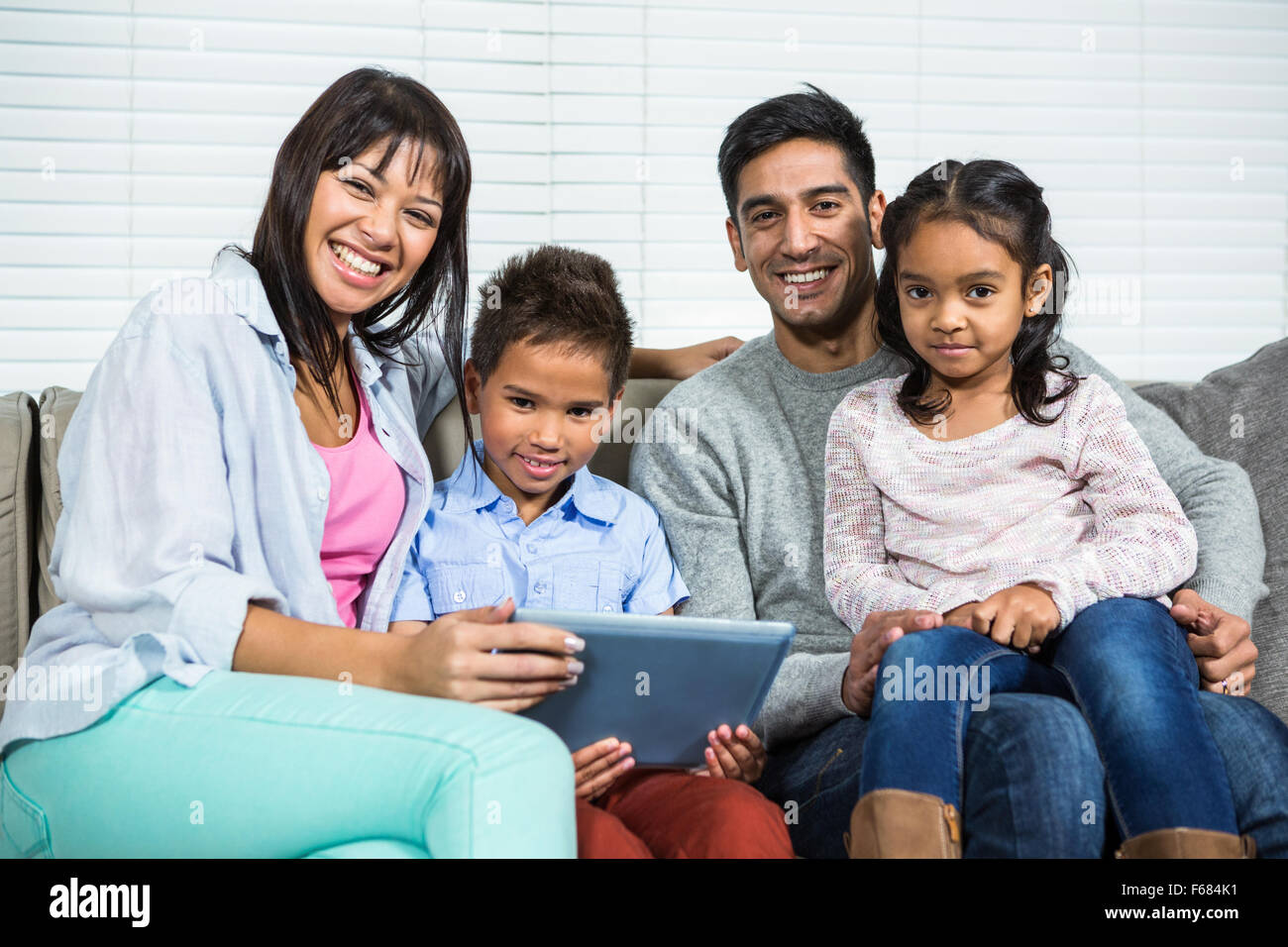 Smiling family using tablet Stock Photo - Alamy